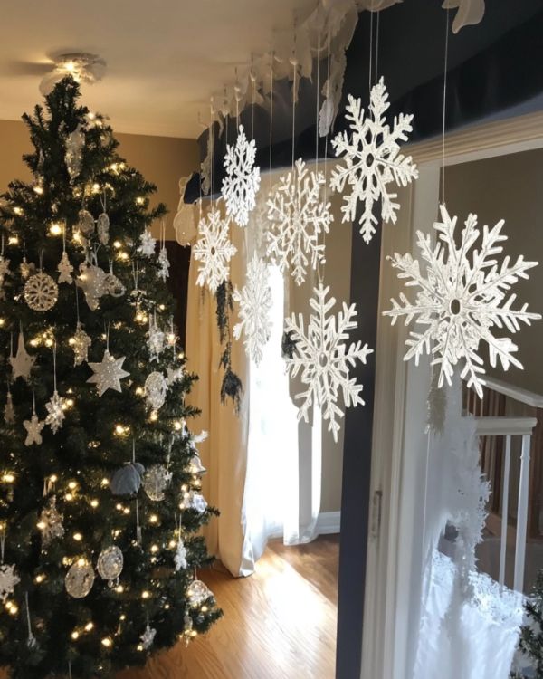 Lady hangs Dollar Store snowflakes from a curtain rod. This is the best ...